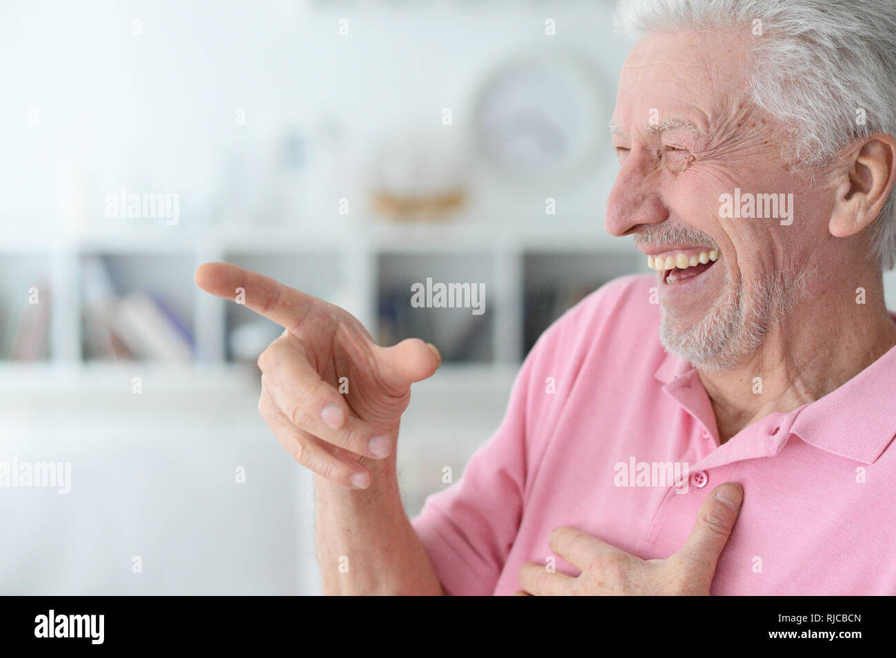 Portrait of happy senior man pointing to the left Stock Photo - Alamy