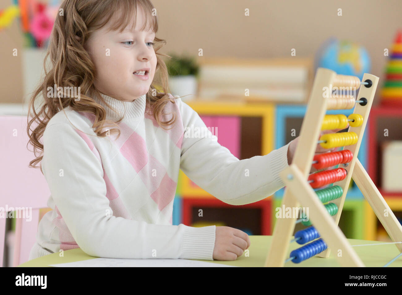 Portrait of little girl counting on abacus Stock Photo - Alamy