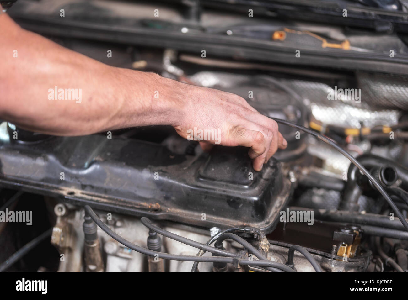 Auto mechanic working on car engine at repair service. Close up view ...