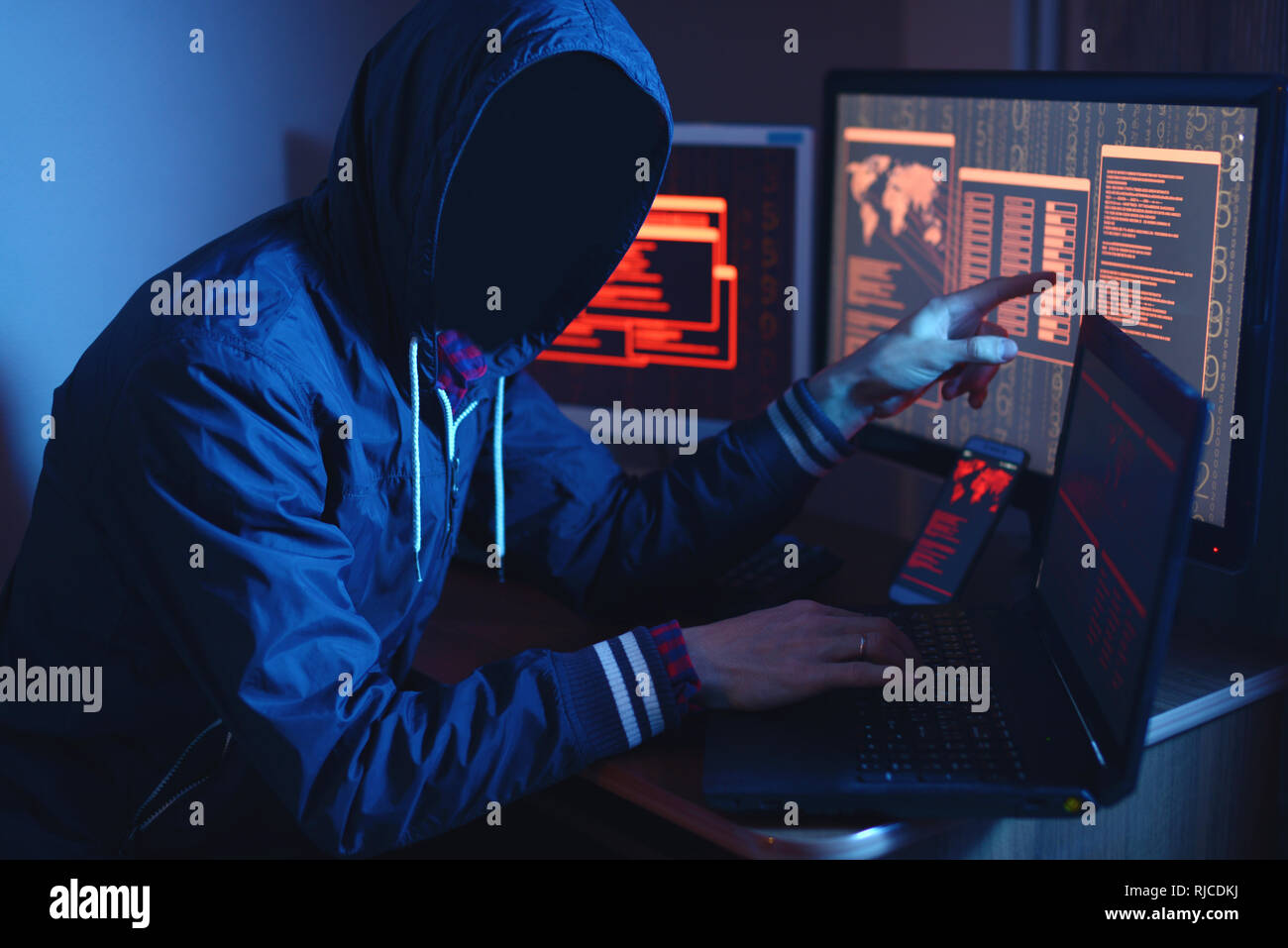 An anonymous hacker with no face typing the code tries to hack the ...