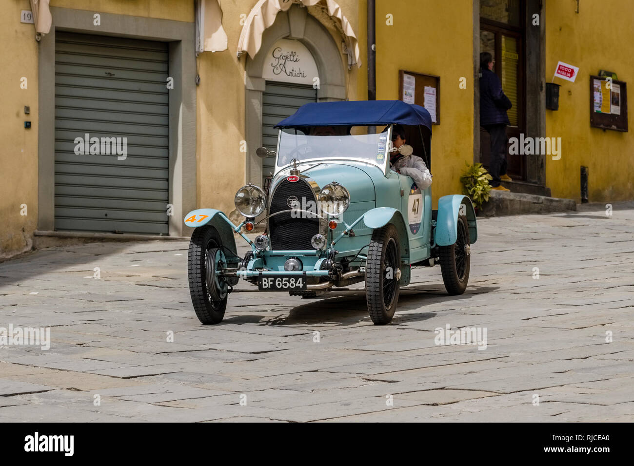 A vintage car, joining the rallye Mille Miglia, driving through the ...