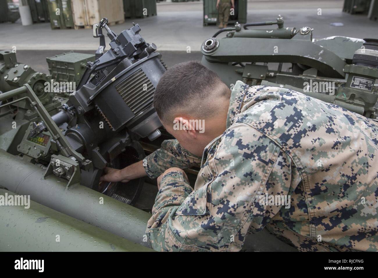 An artilleryman with 5th Battalion, 11th Marine Regiment adjusts the ...