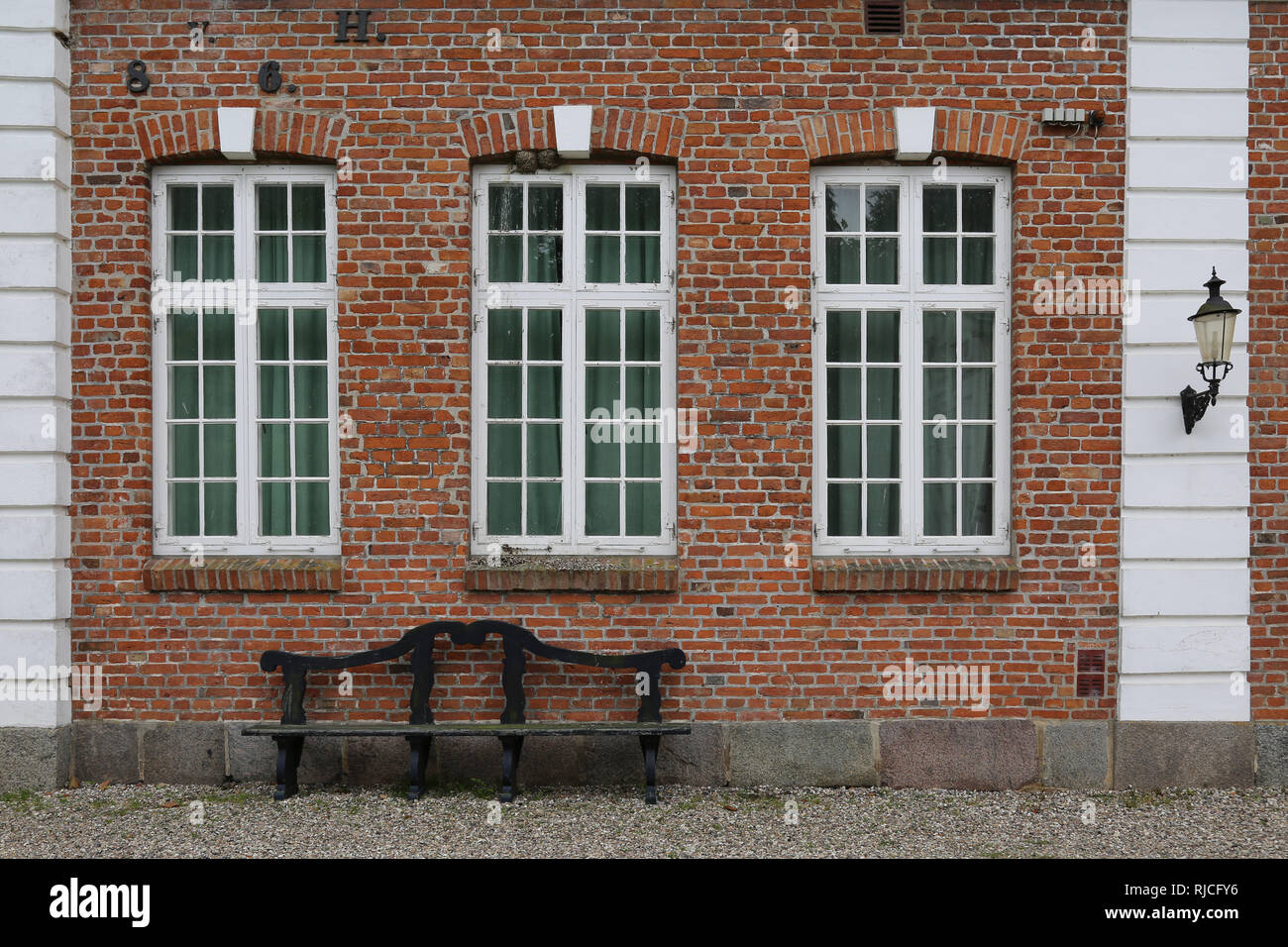 brick facade with bench, window and lantern Stock Photo - Alamy