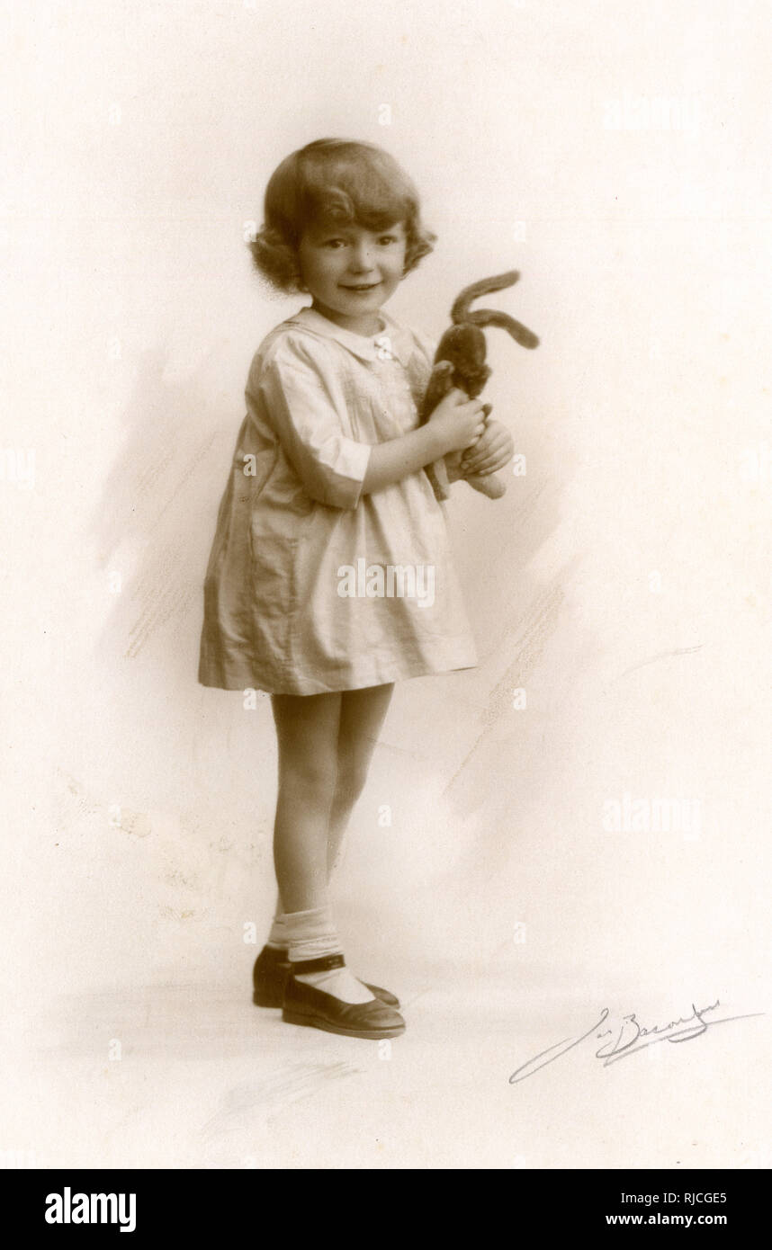 Little girl holds a toy rabbit, circa 1930s Stock Photo - Alamy