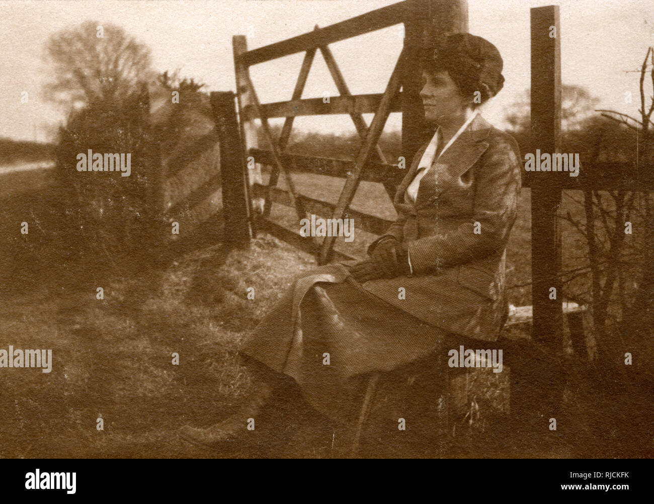 Woman sitting on a stile by a five-bar gate Stock Photo - Alamy