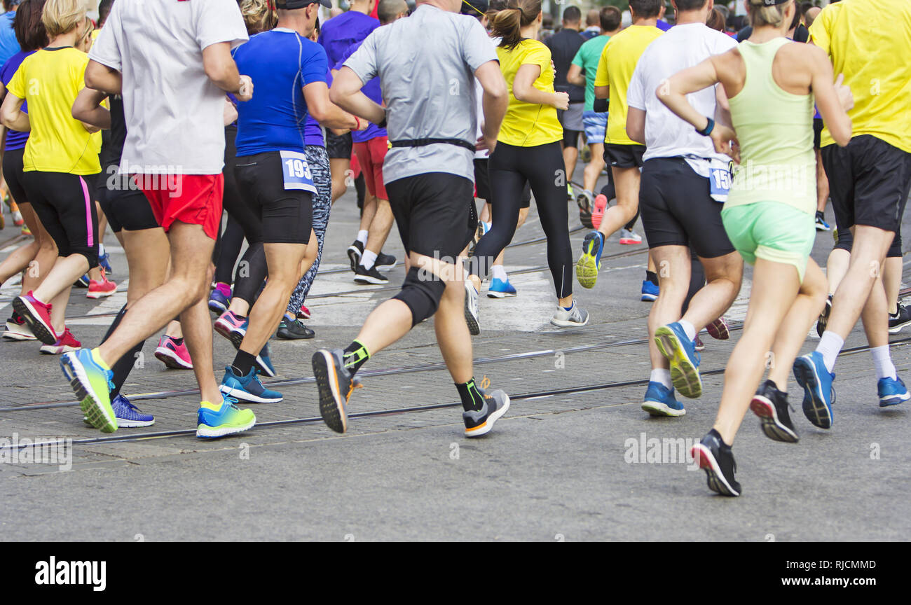 Marathon runners running race people feet on city road Stock Photo - Alamy
