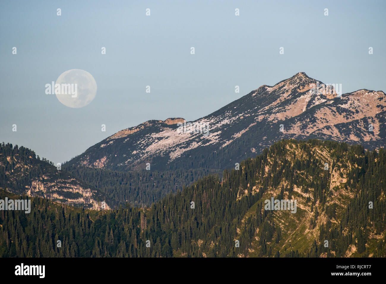 full moon sets behind Reither Alm or Reither Alpe mountains, to the ...