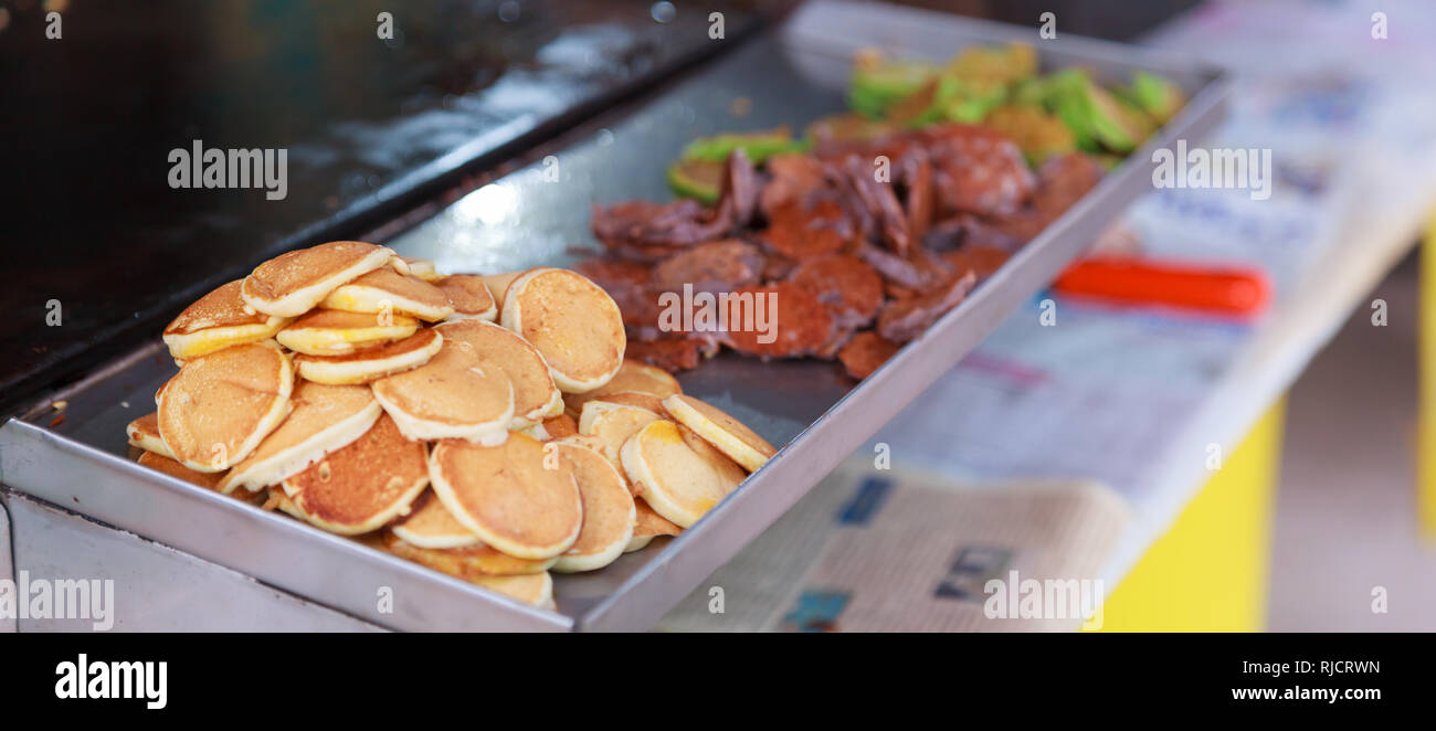 Freshly hot baked traditional Thai sponge soft pancake on hot fry pan ...