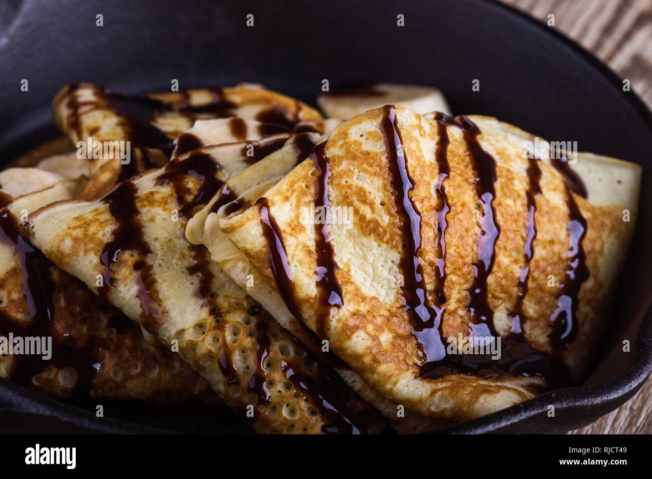 Homemade crepes with bananas and chocolate topping for breakfast in ...
