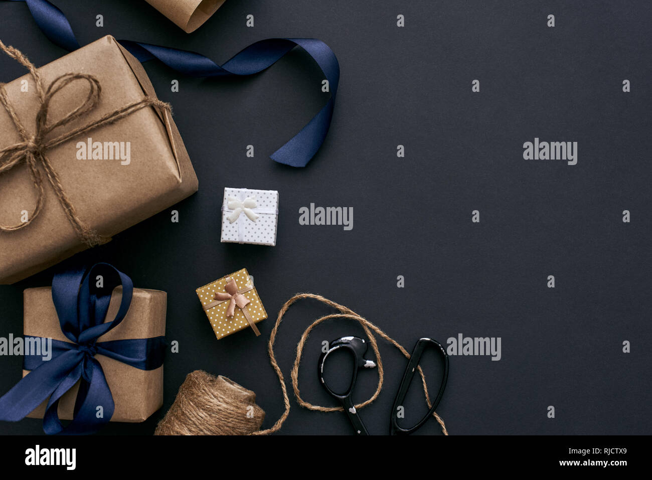 Creative gift boxes on dark background. Wrapping with brown paper ...