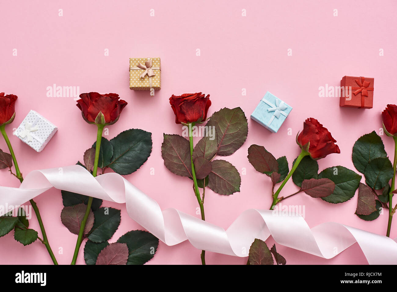 Love is a in the air. Red roses with cute colorful gist boxes and white ...