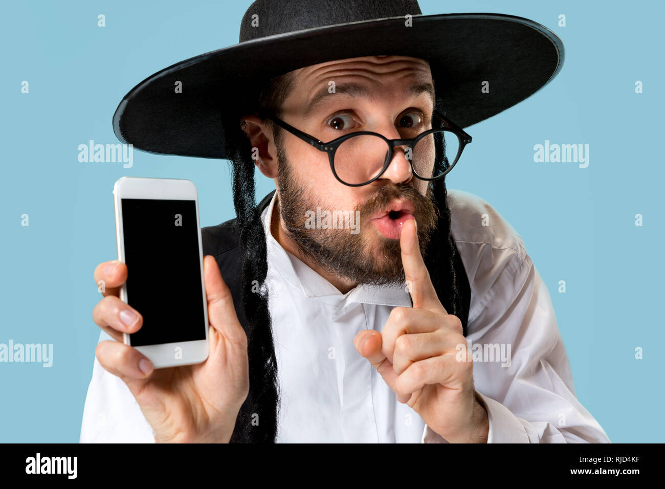 Portrait of a young orthodox Hasdim Jewish man with mobile phone at ...