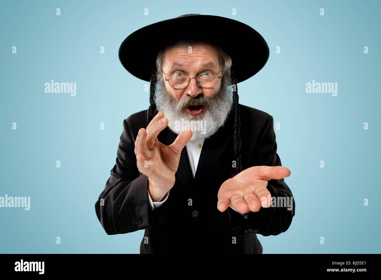 Portrait of old senior orthodox Hasdim Jewish man with wooden Grager ...