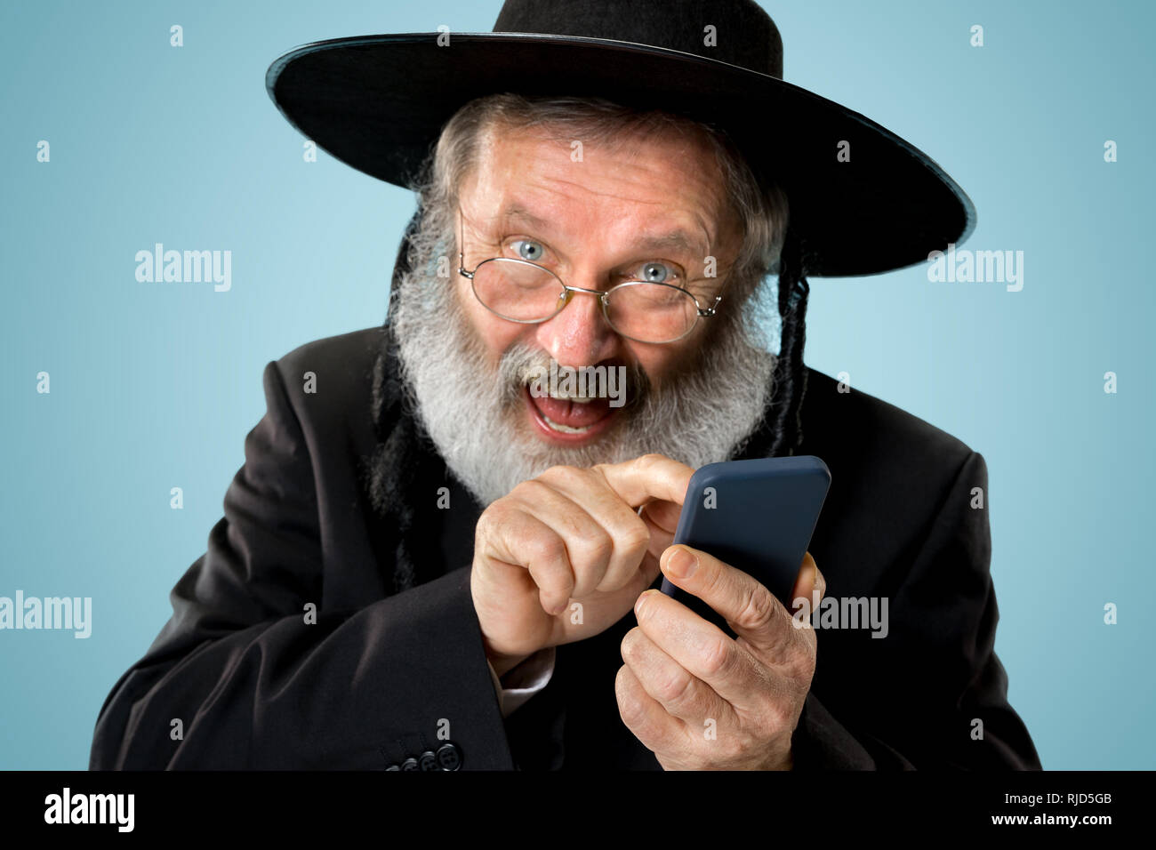 Portrait of old senior orthodox Hasdim Jewish man with mobile phone at ...