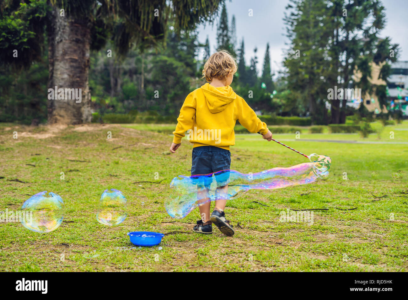 Cute little boy is playing with big bubbles outdoor Stock Photo - Alamy