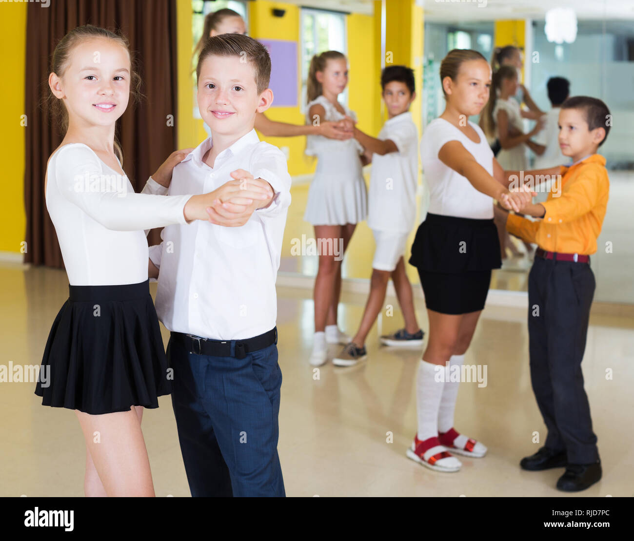 Portrait of active glad children enjoying of partner dance in class ...