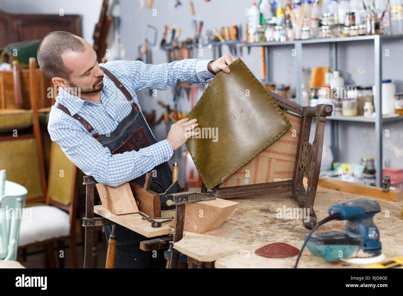 Furniture restorer renovation antique chair in his woodwork studio ...
