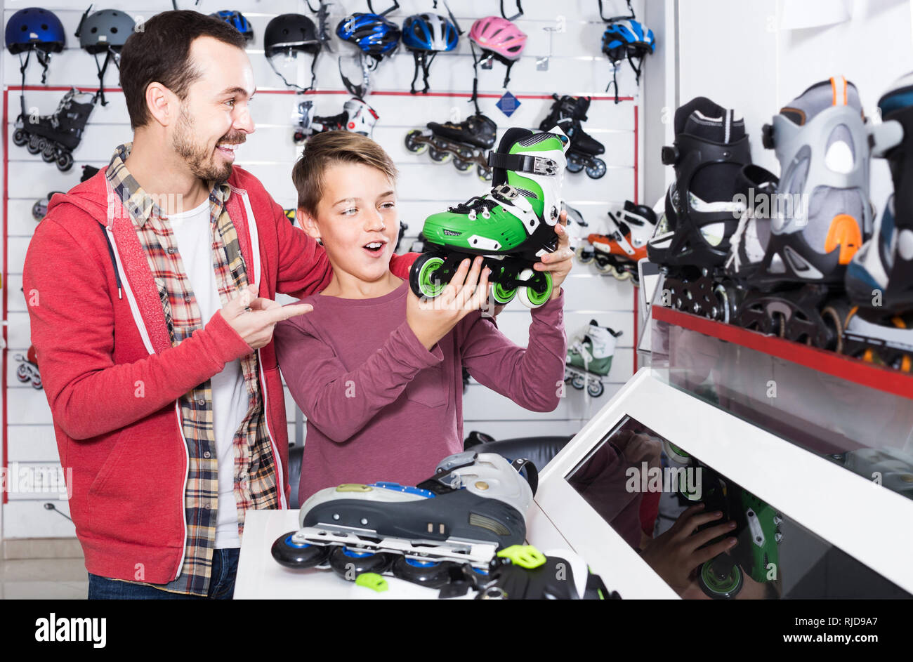 positive european father and son deciding on new roller-skates in ...