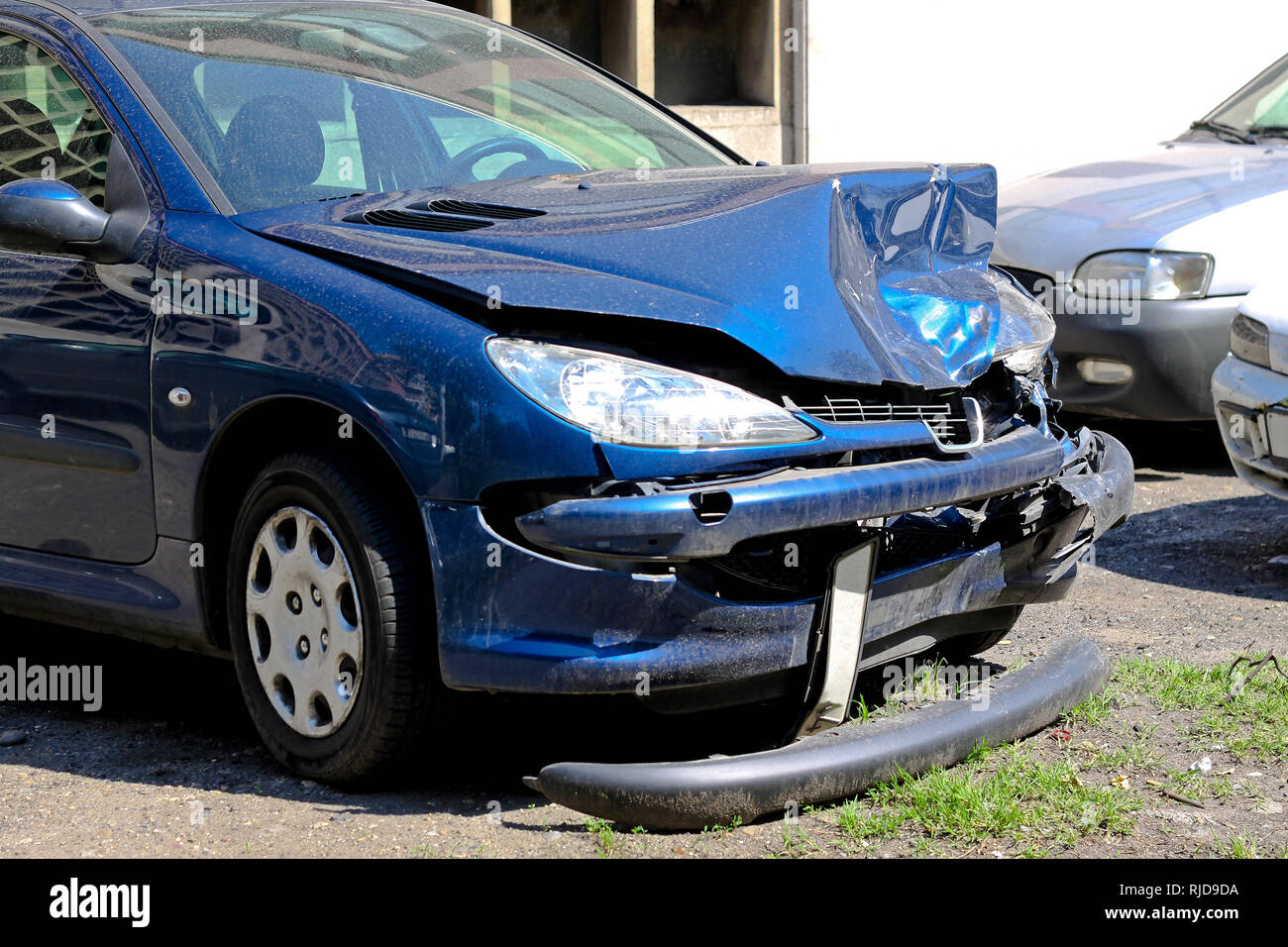 Small blue car smashed in traffic accident Stock Photo - Alamy