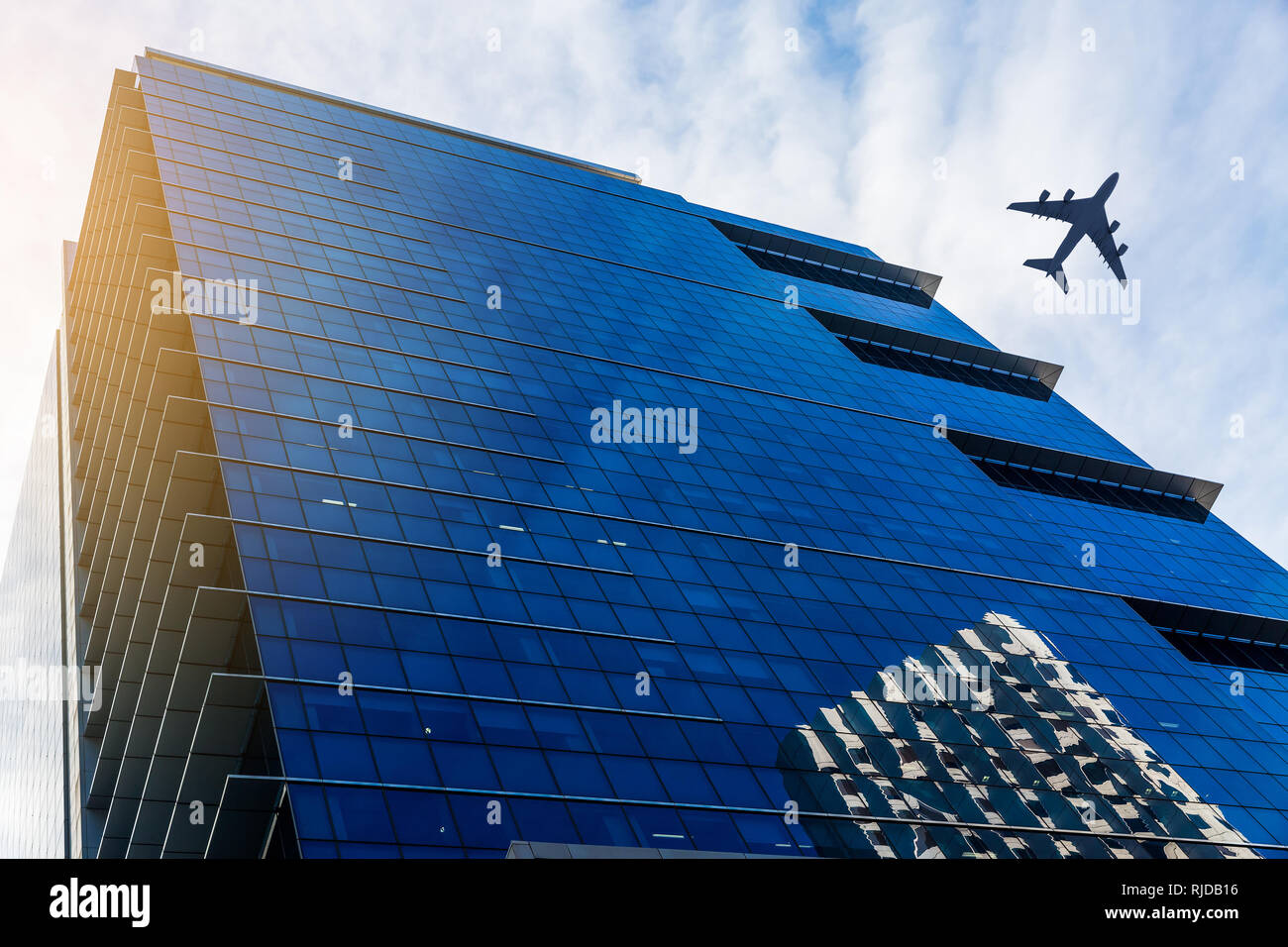 Bottom angle view of airplane in sky over city buildings Stock Photo ...