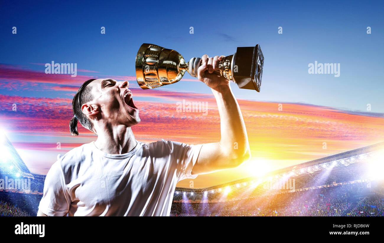 Athlete drinking from cup trophy against stadium. Mixed media Stock ...