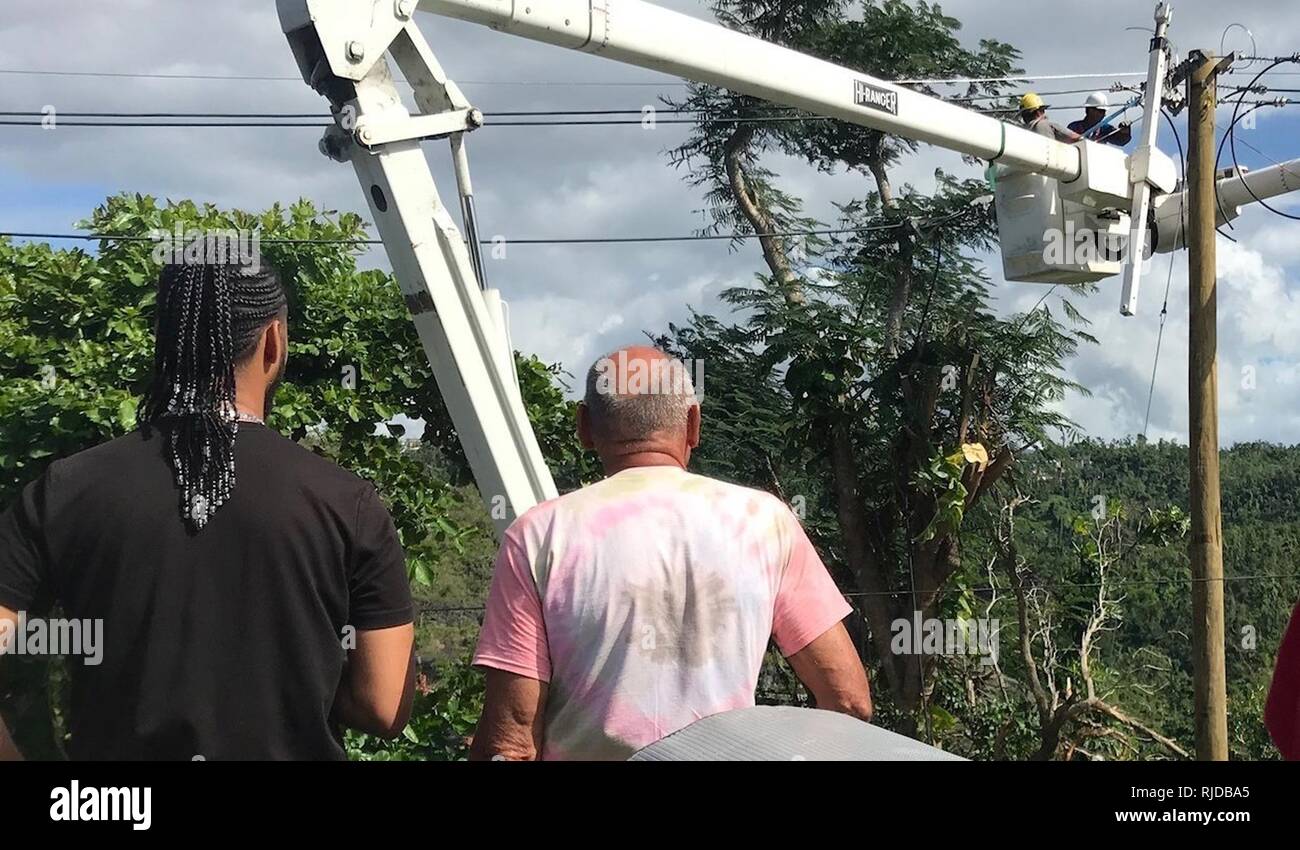CAROLINA, Puerto Rico – Neighbors Joshua Sanchez and Juan Cabeza watch ...