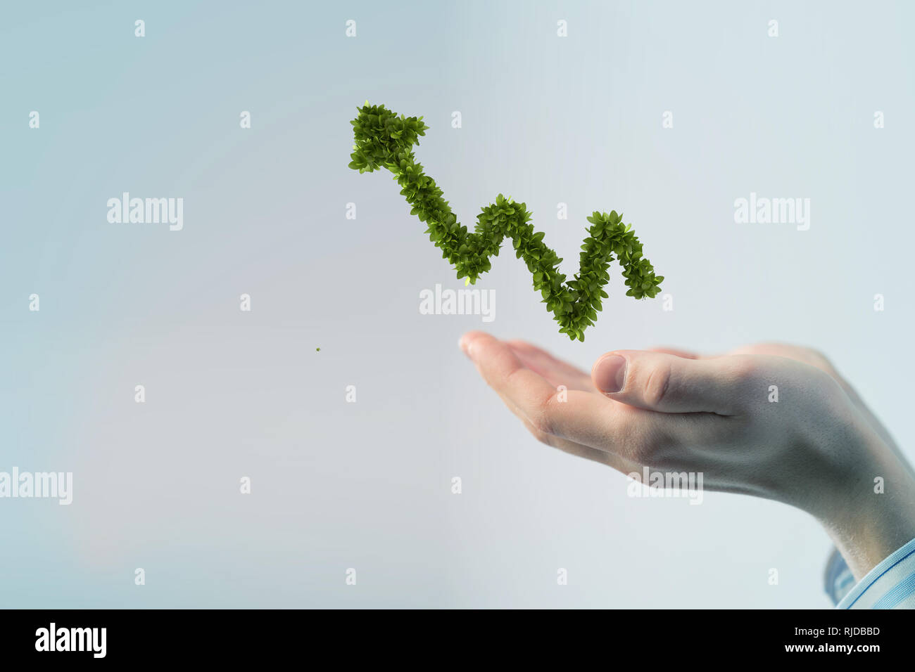 Hand of businessman holding green growing graph Stock Photo - Alamy