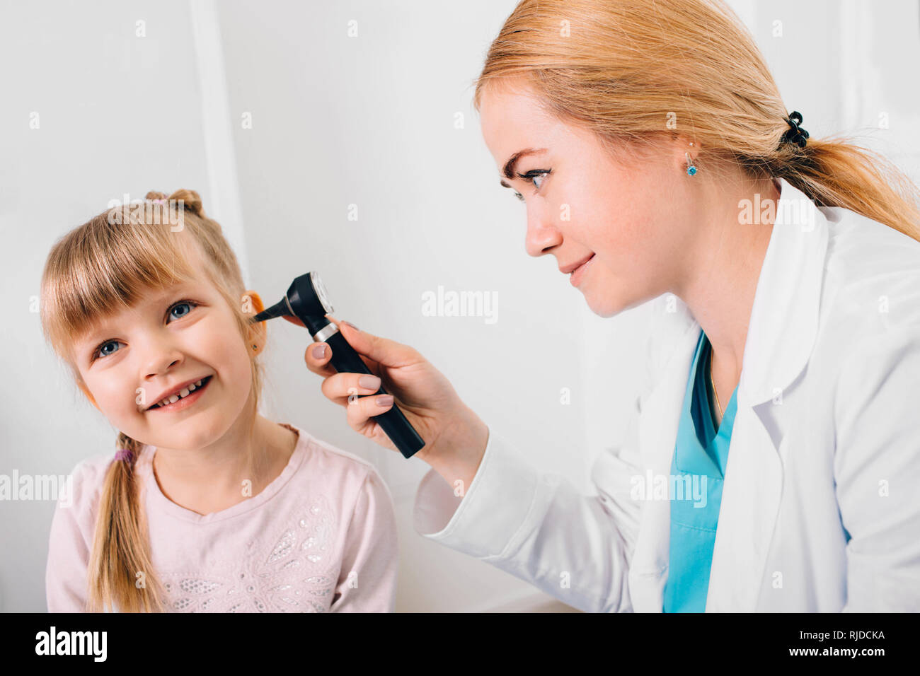 Smiling little girl having ear exam with otoscope Stock Photo - Alamy