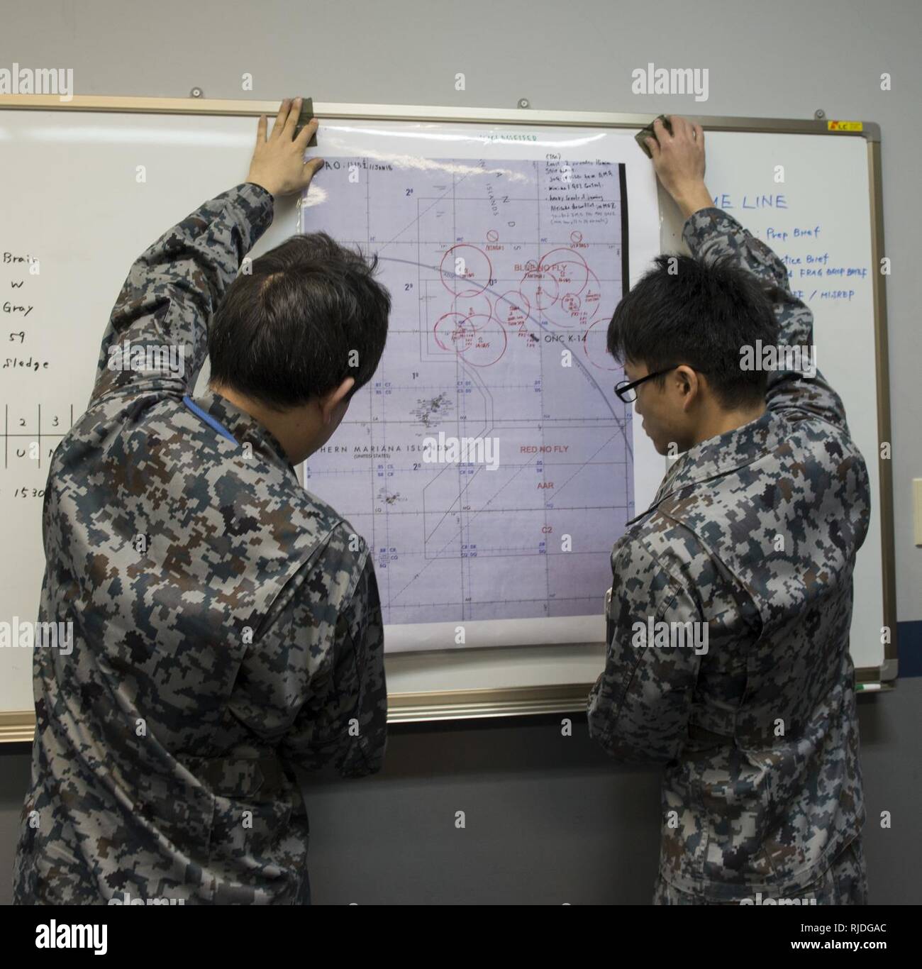 Japan Air Self Defense Force officers hang a map during a bilateral ...
