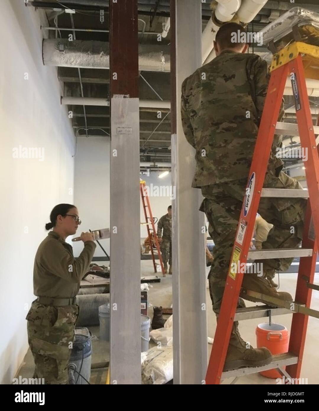 Soldiers from the 424th Vertical Engineering Company are shown painting ...