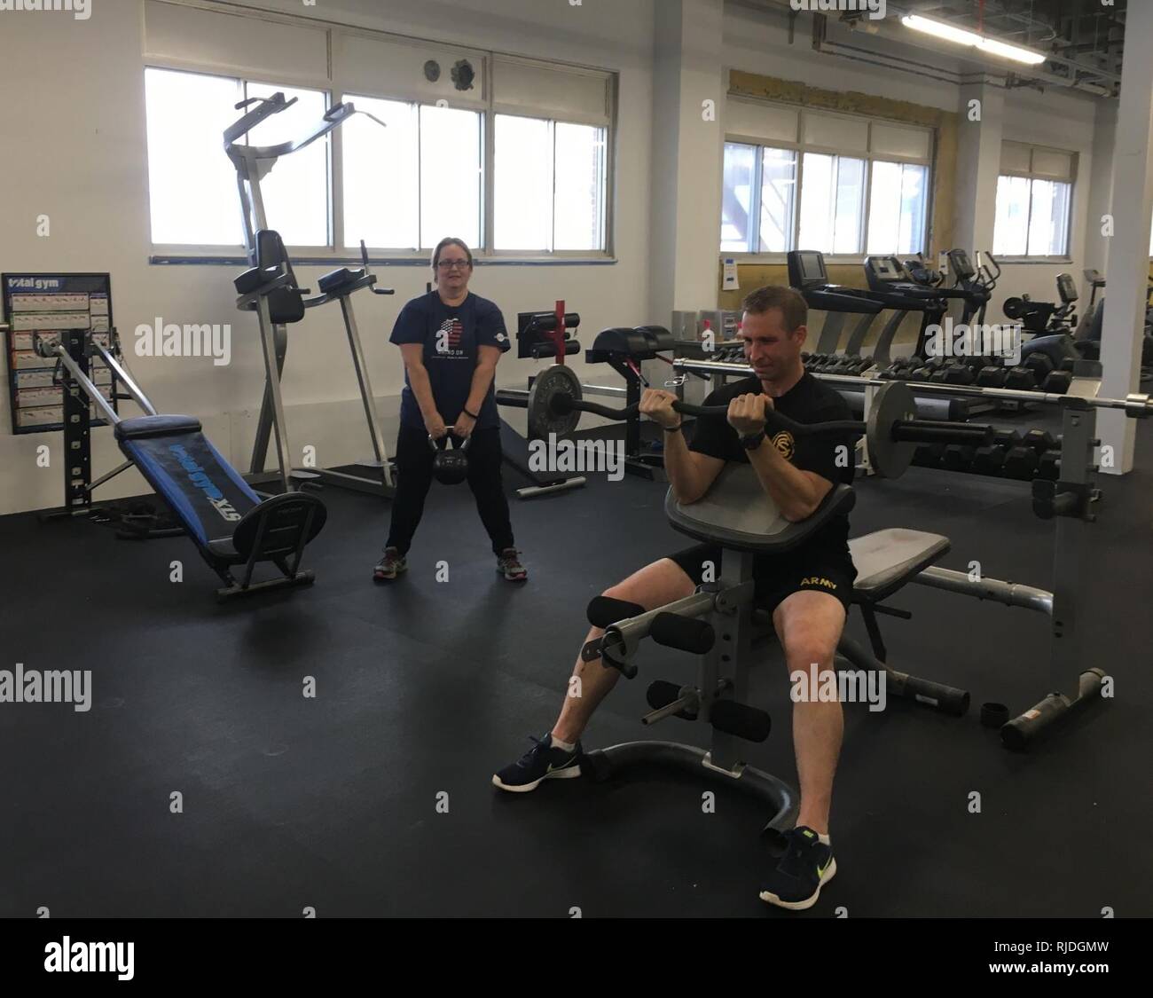 Michelle Beane works out with a kettlebell while Capt. Joe Marut works ...