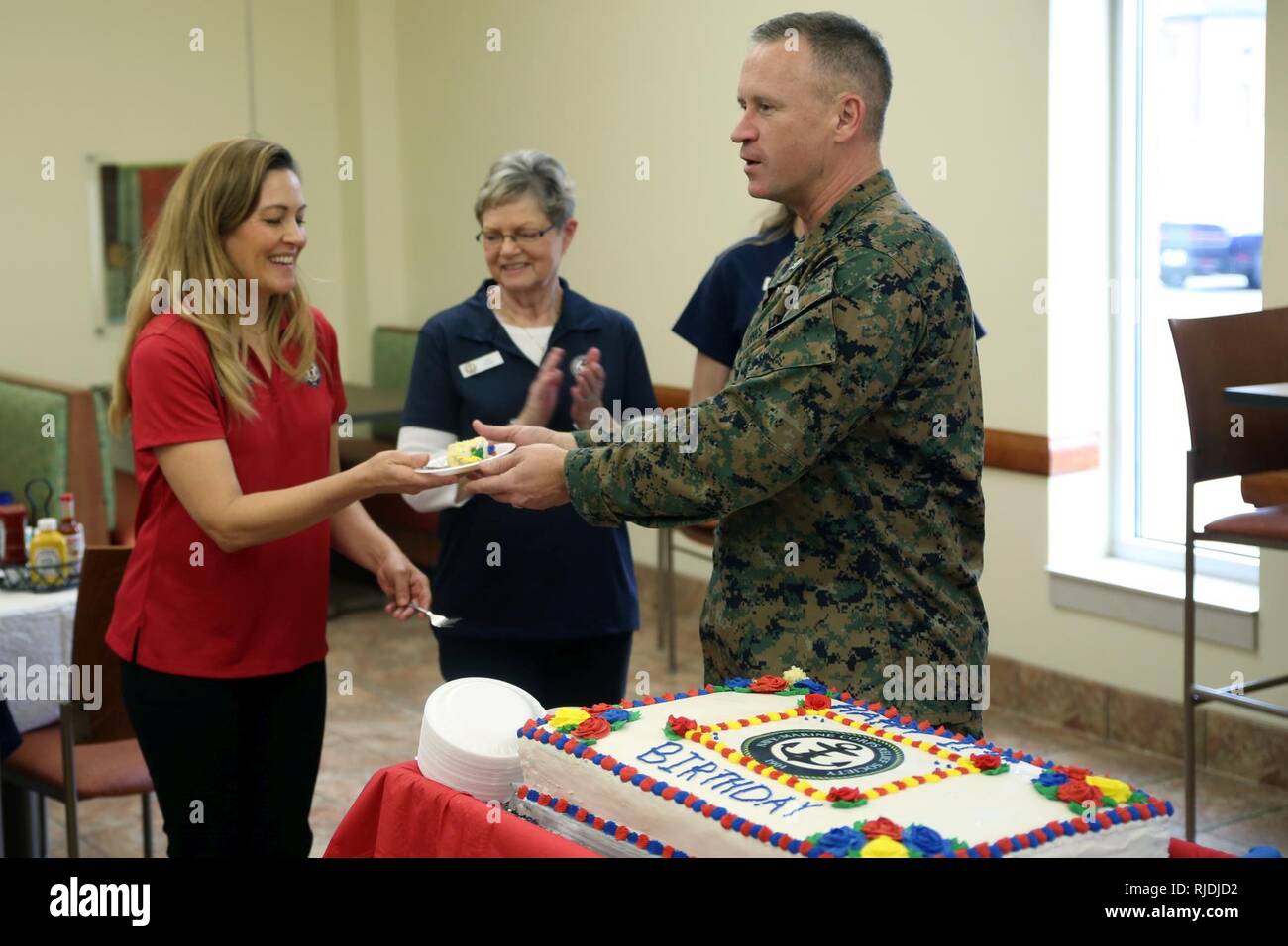 Col. Todd Ferry, right, passes a piece of cake to Julie Spangenberger ...