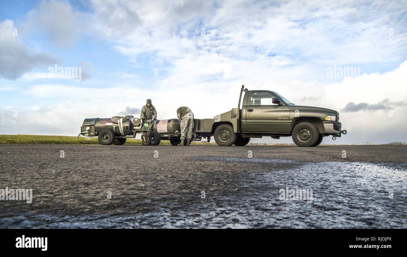 Airmen from the 5th Logistics Readiness Squadron attach lox carts to a ...