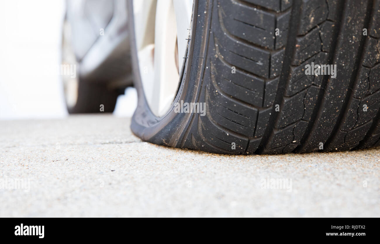 Close Up photo of a flat tire on a bright sunny day Stock Photo - Alamy