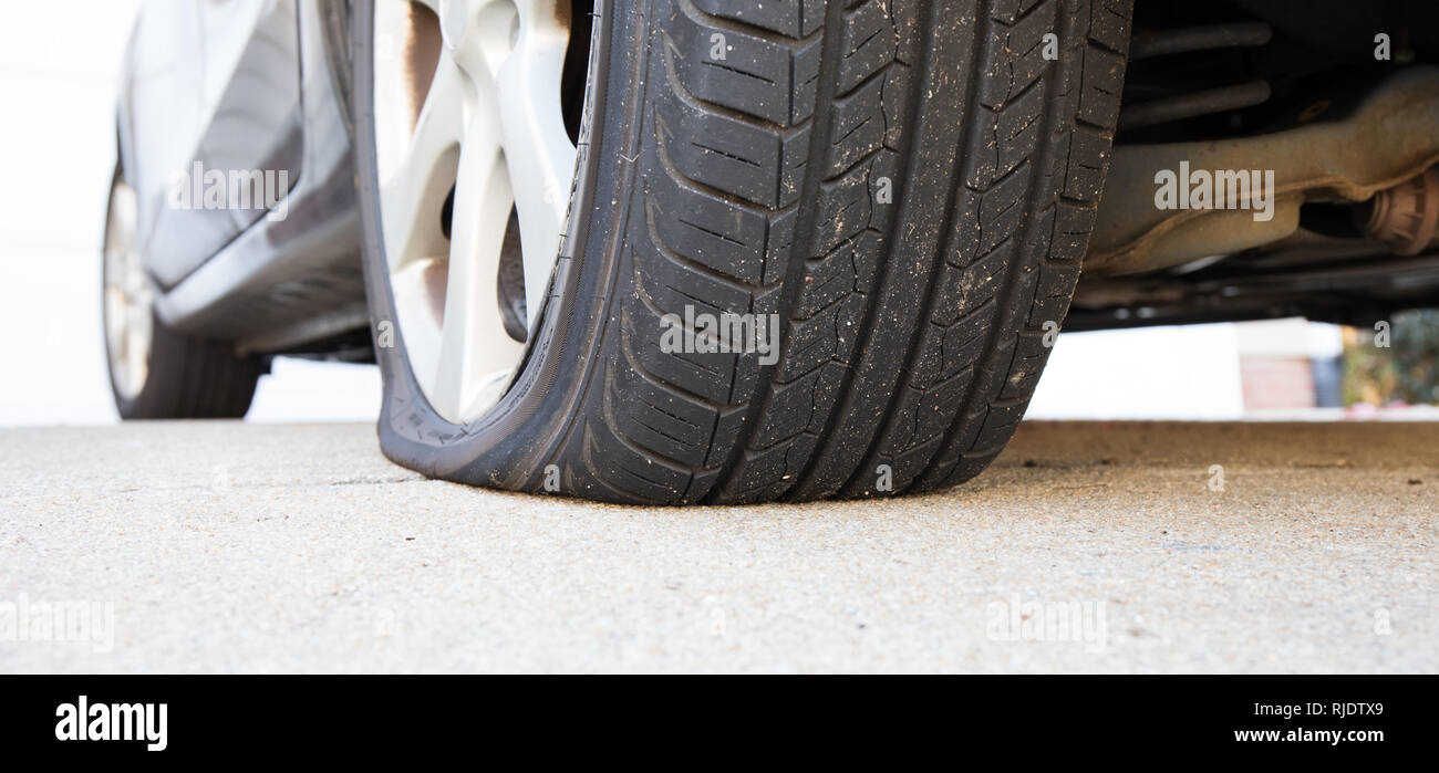Close Up photo of a flat tire on a bright sunny day Stock Photo - Alamy