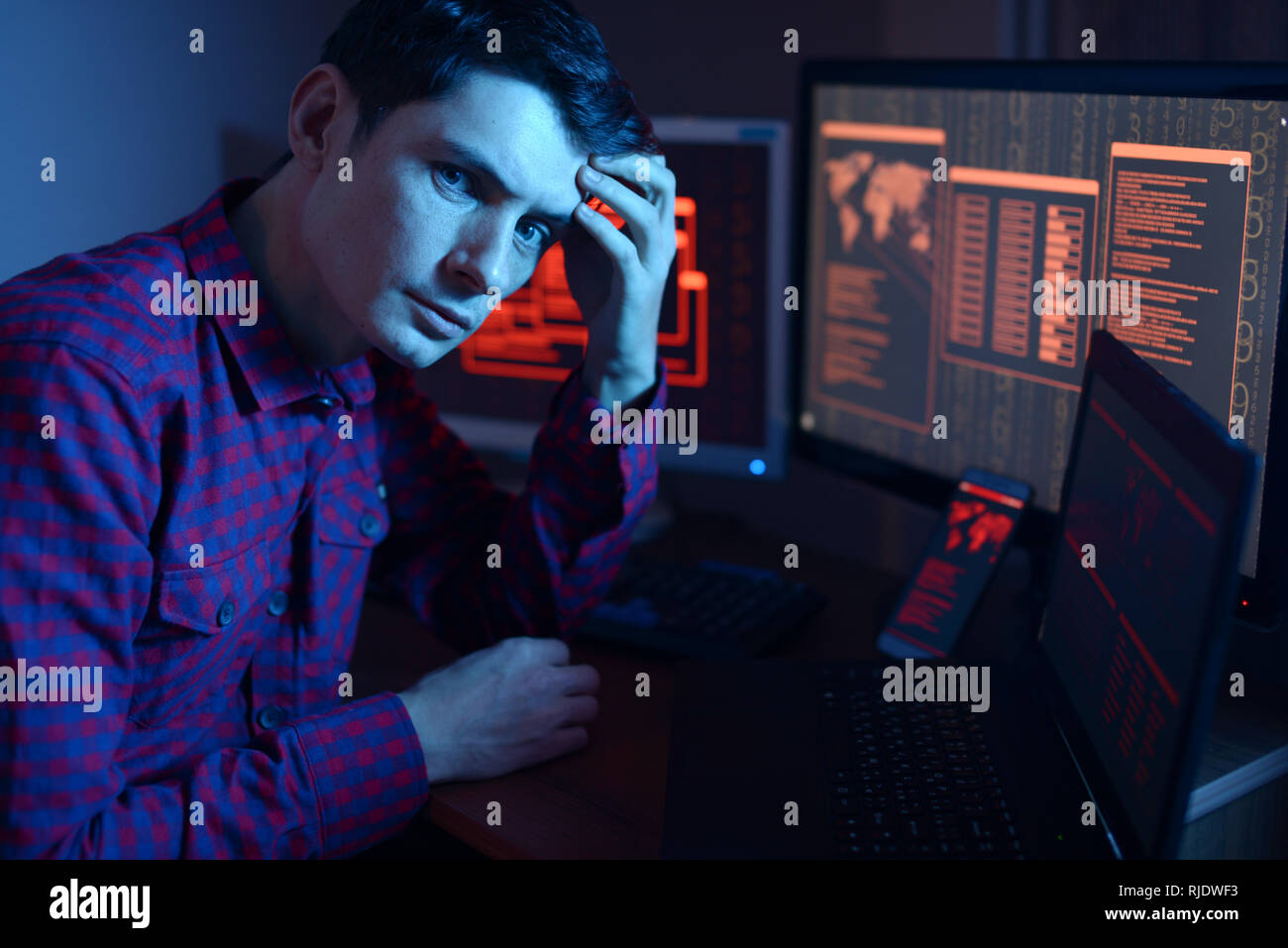 Male hacker thinking about the problem of hacking or malware infection ...