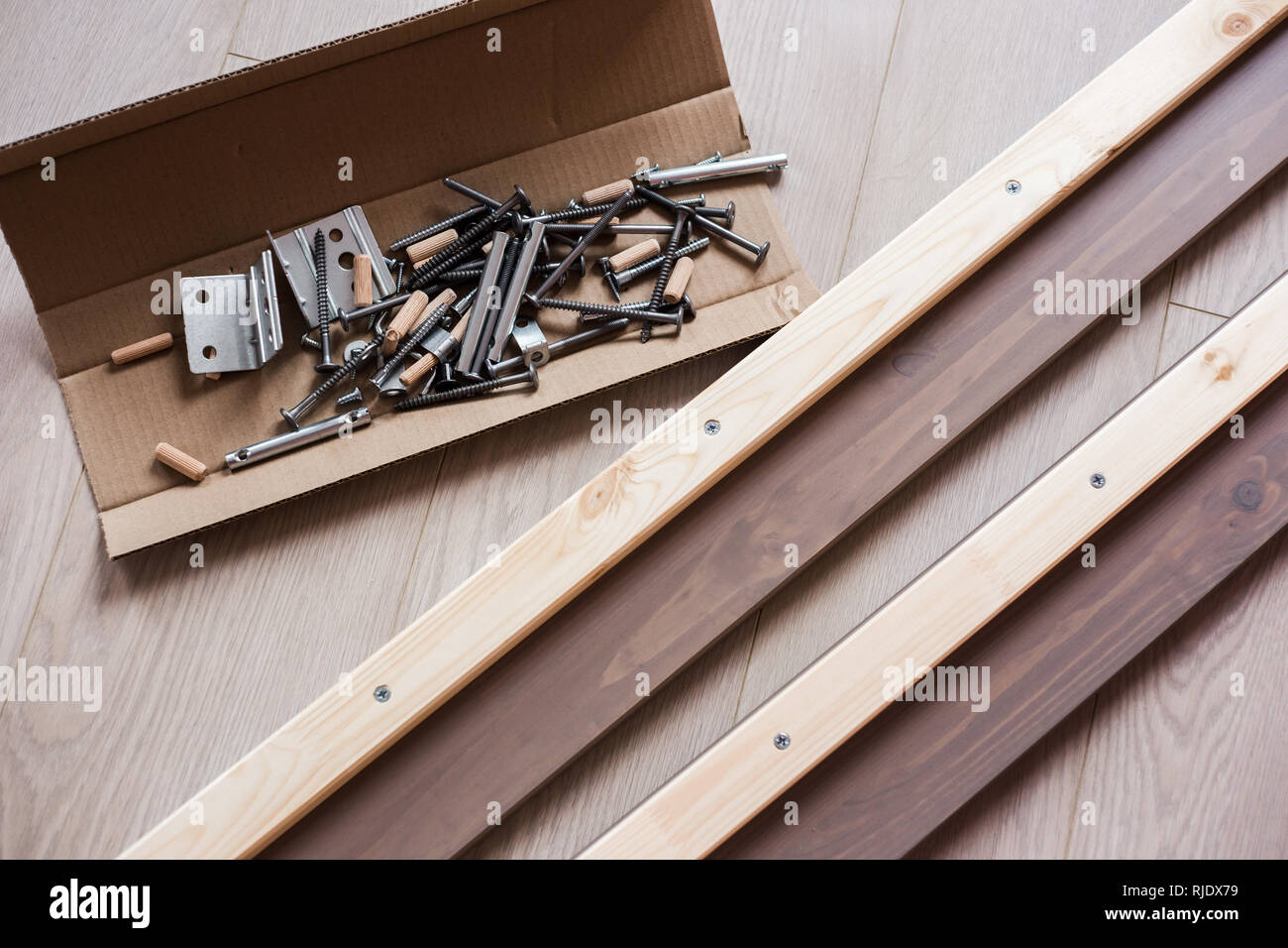 Furniture fittings, screws and other parts in open craft box lying on ...