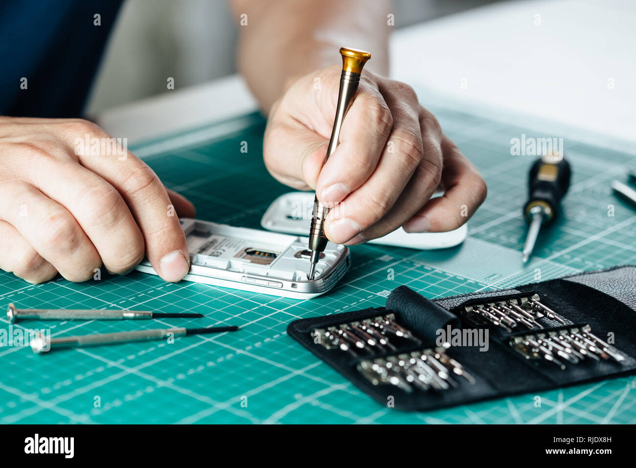 Electronics repair service. Technician disassembling smartphone for ...