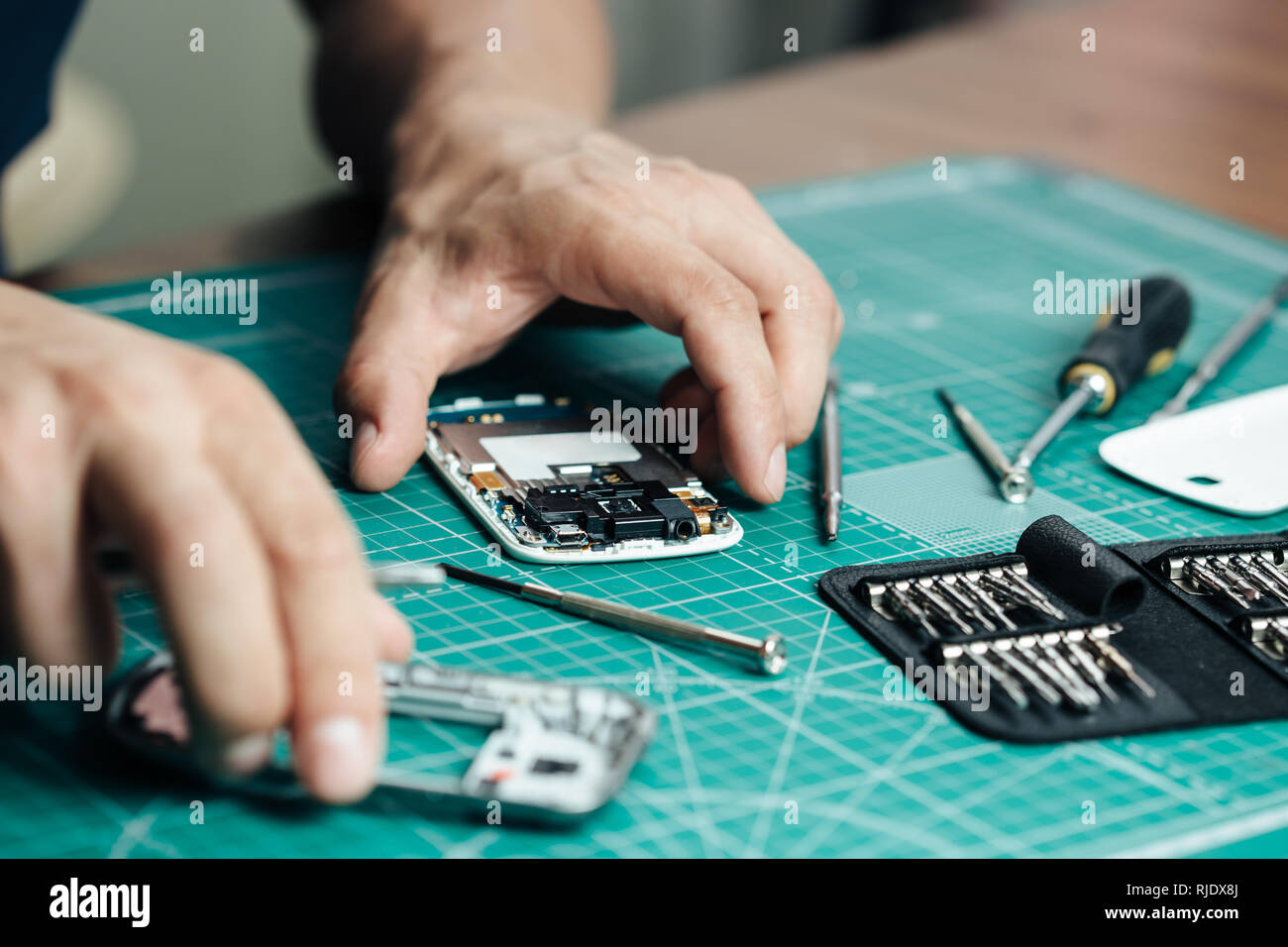 Electronics repair service. Technician disassembling smartphone for ...