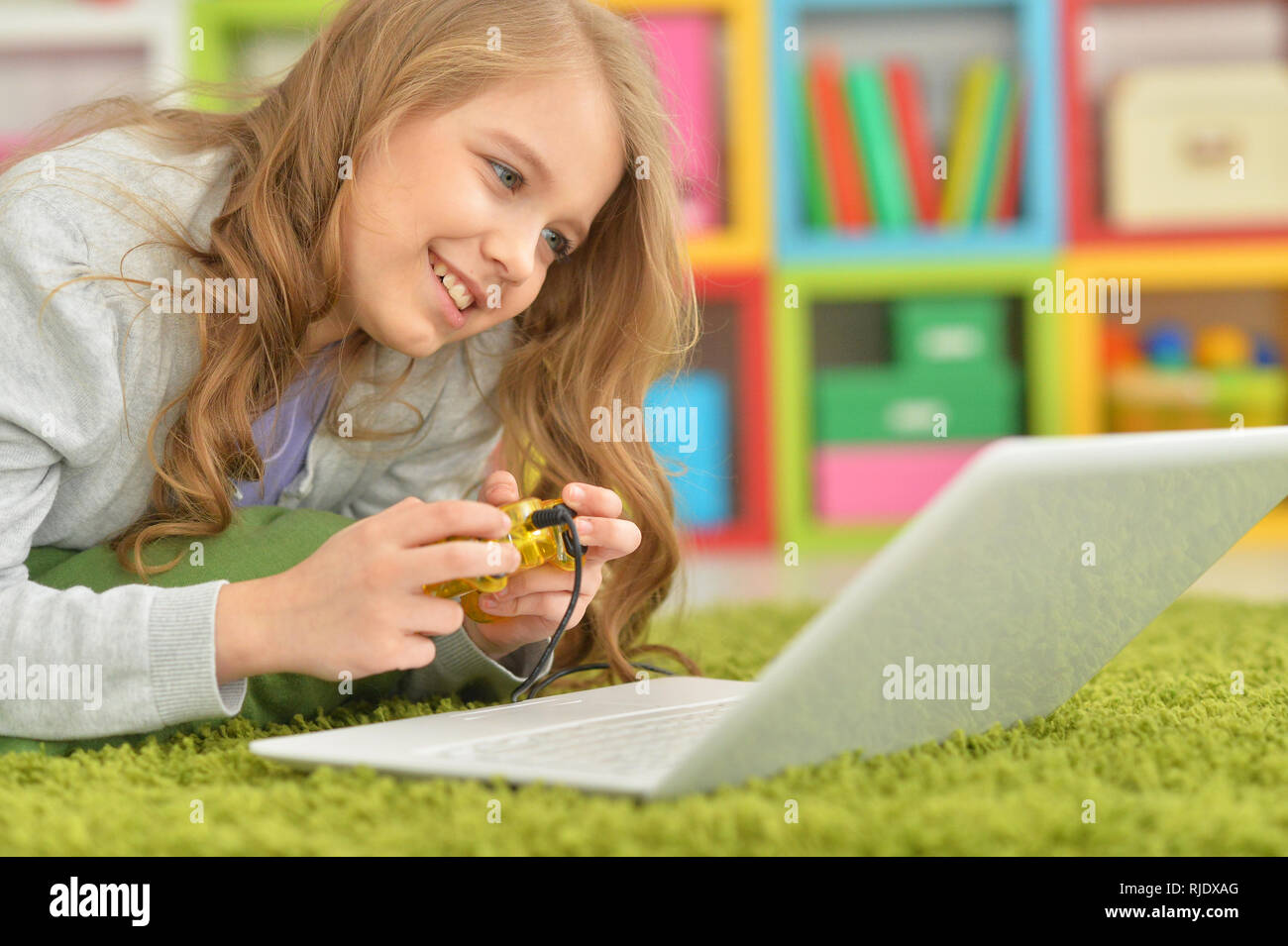 Portrait of little girl playing computer game Stock Photo - Alamy