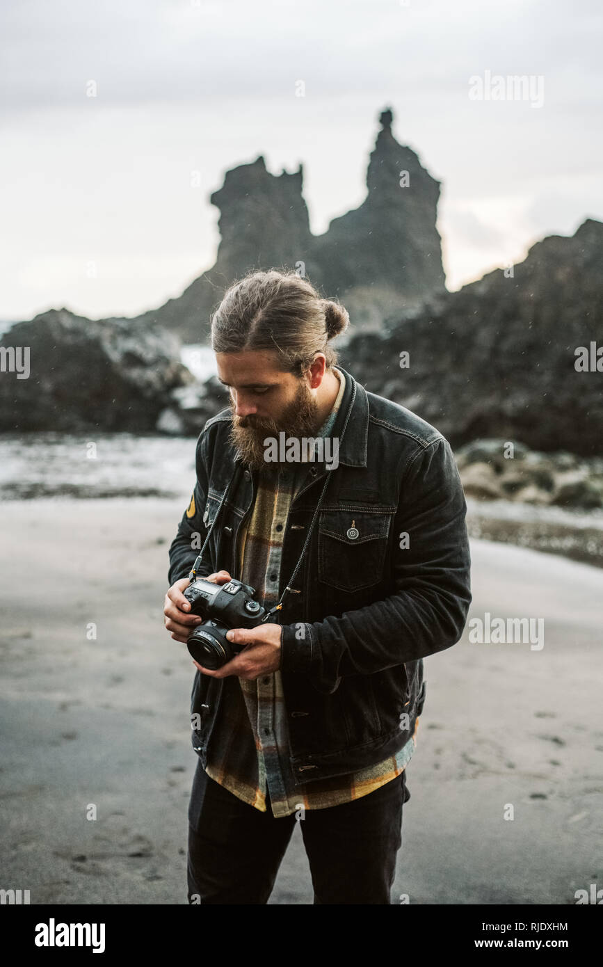 Bearded photographer standing near sea Stock Photo - Alamy