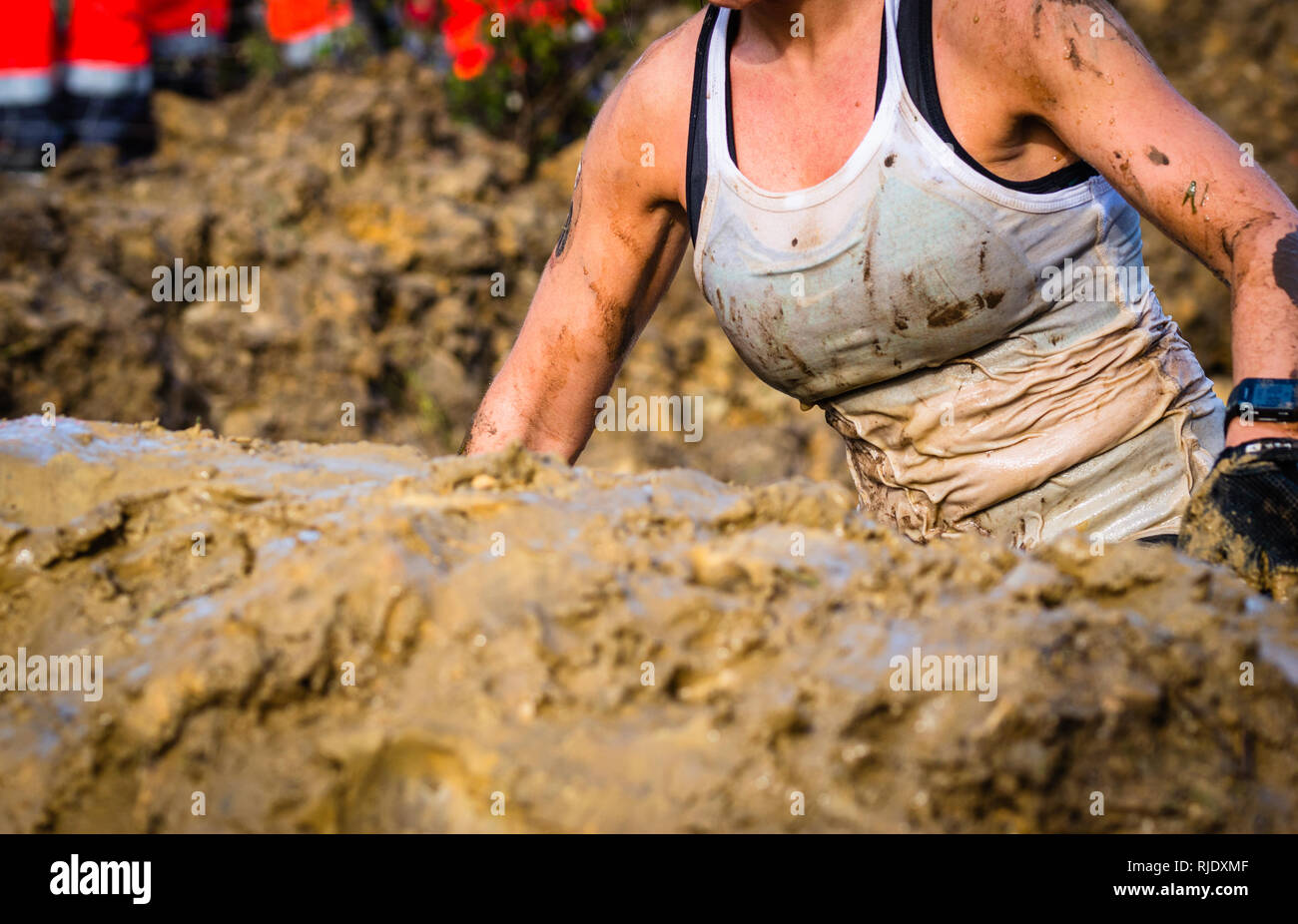 Mud race runners, defeating obstacles by using ropes. Details of the ...