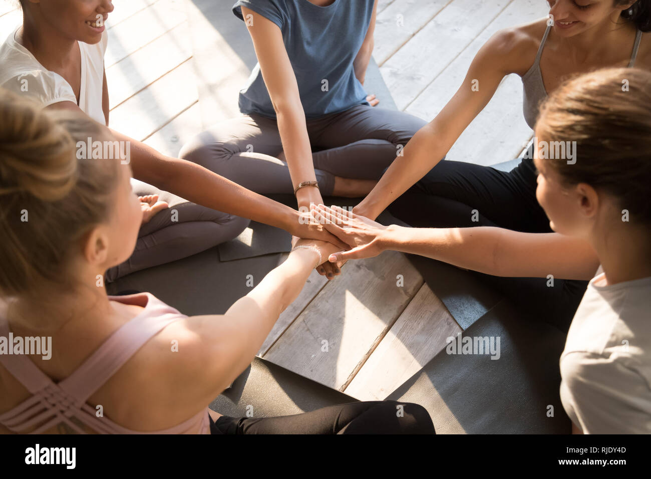 Top view of fit women stack hands showing unity Stock Photo - Alamy