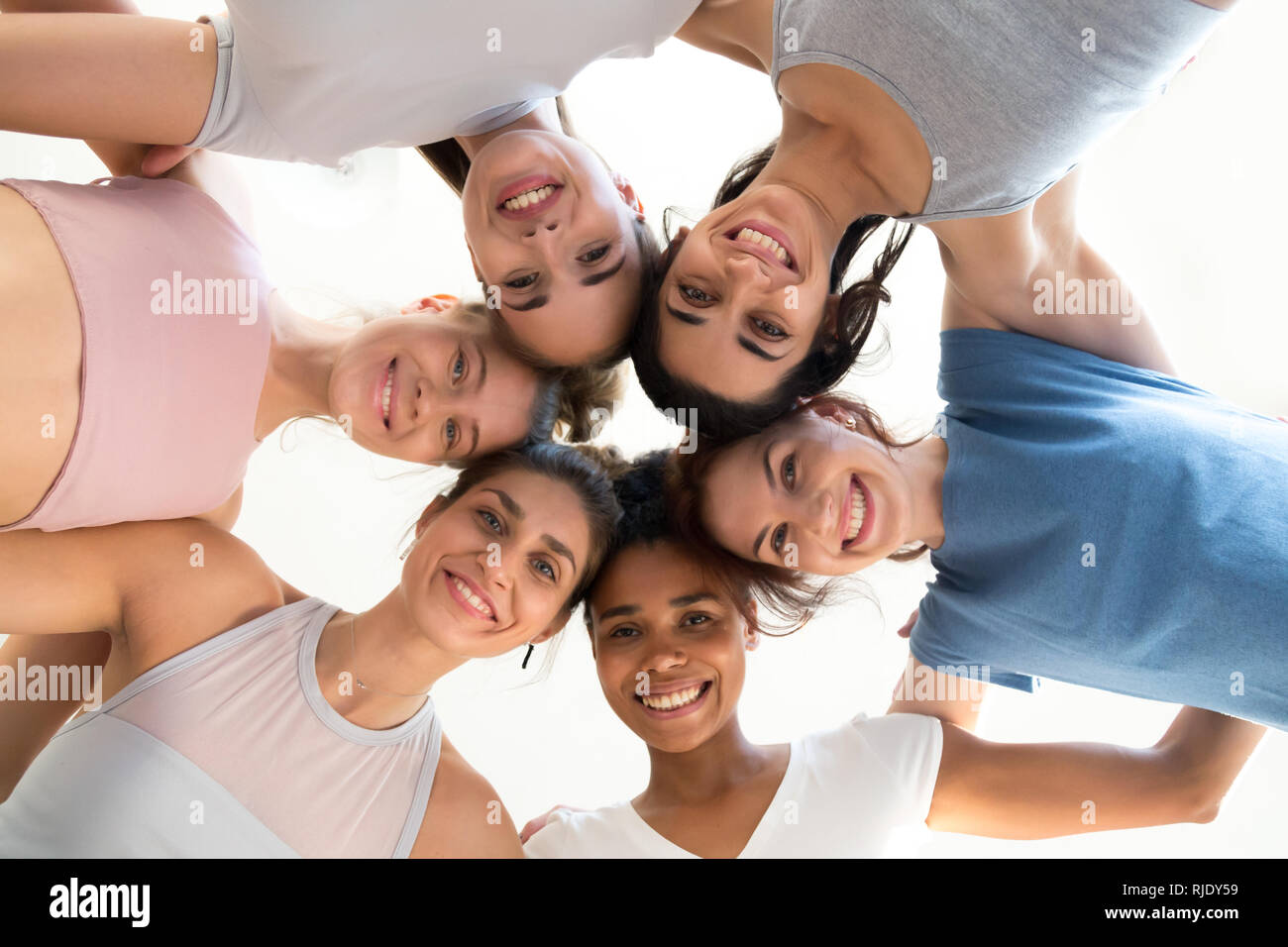 Excited girls hug at training involved in motivational activity Stock ...