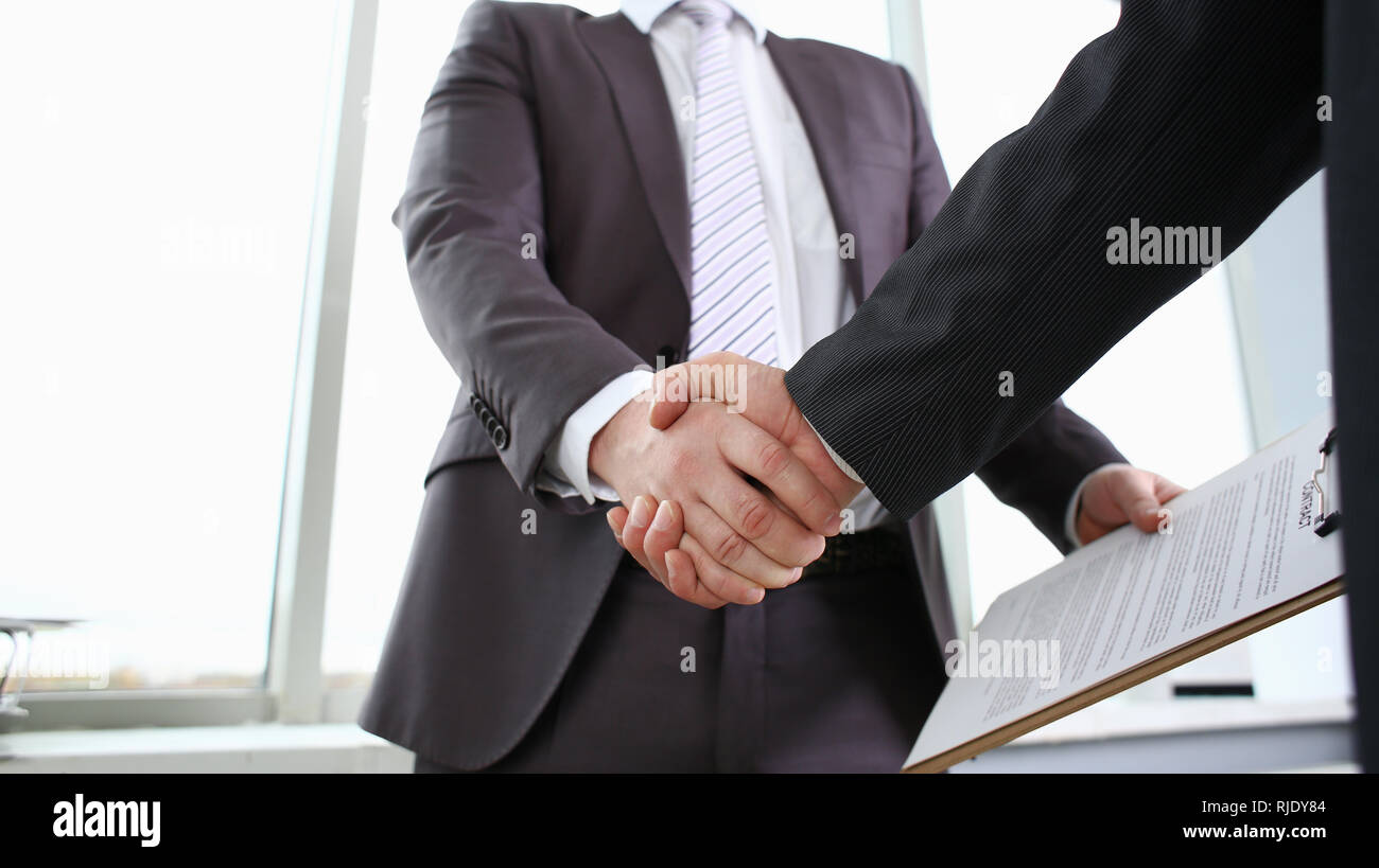Man in suit shake hand as hello in office Stock Photo - Alamy