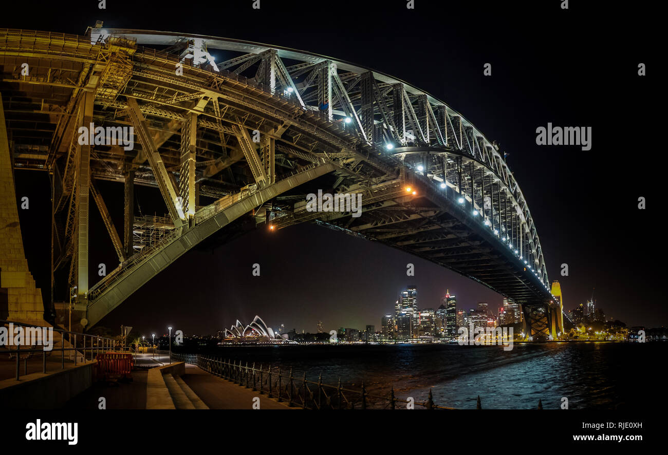 East side of Sydney harbour bridge at nihgt with bright reflecting in ...