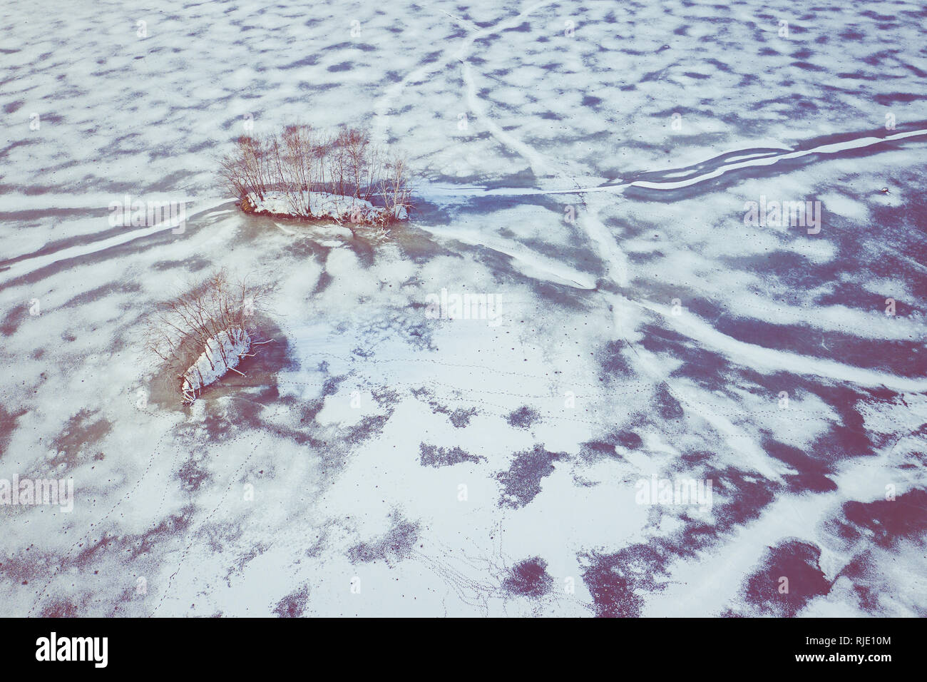 Aerial view of the winter snow covered forest and frozen lake from ...