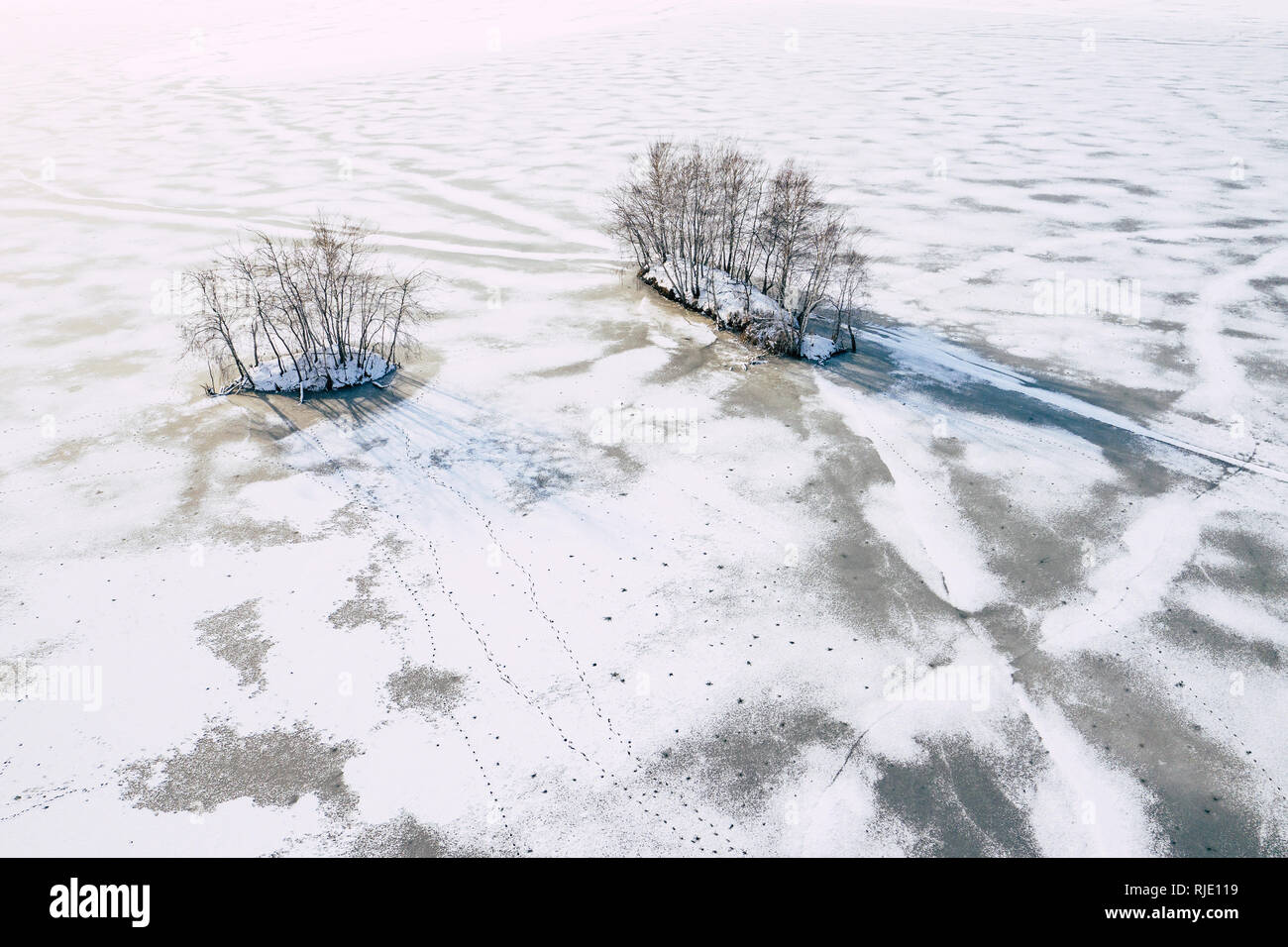 Aerial view of the winter snow covered forest and frozen lake from ...