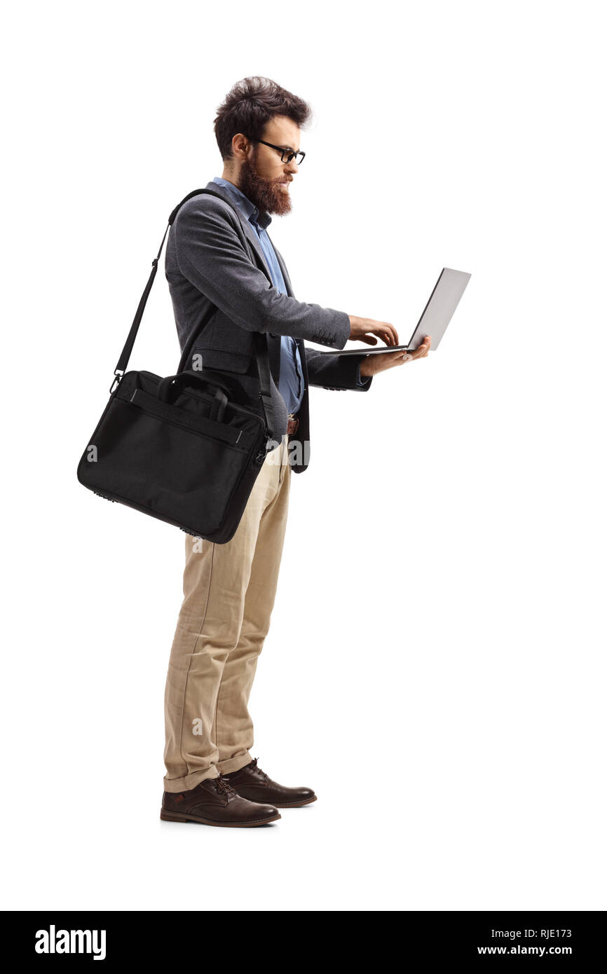 Full length shot of a man standing with a shoulder bag and typing on a ...