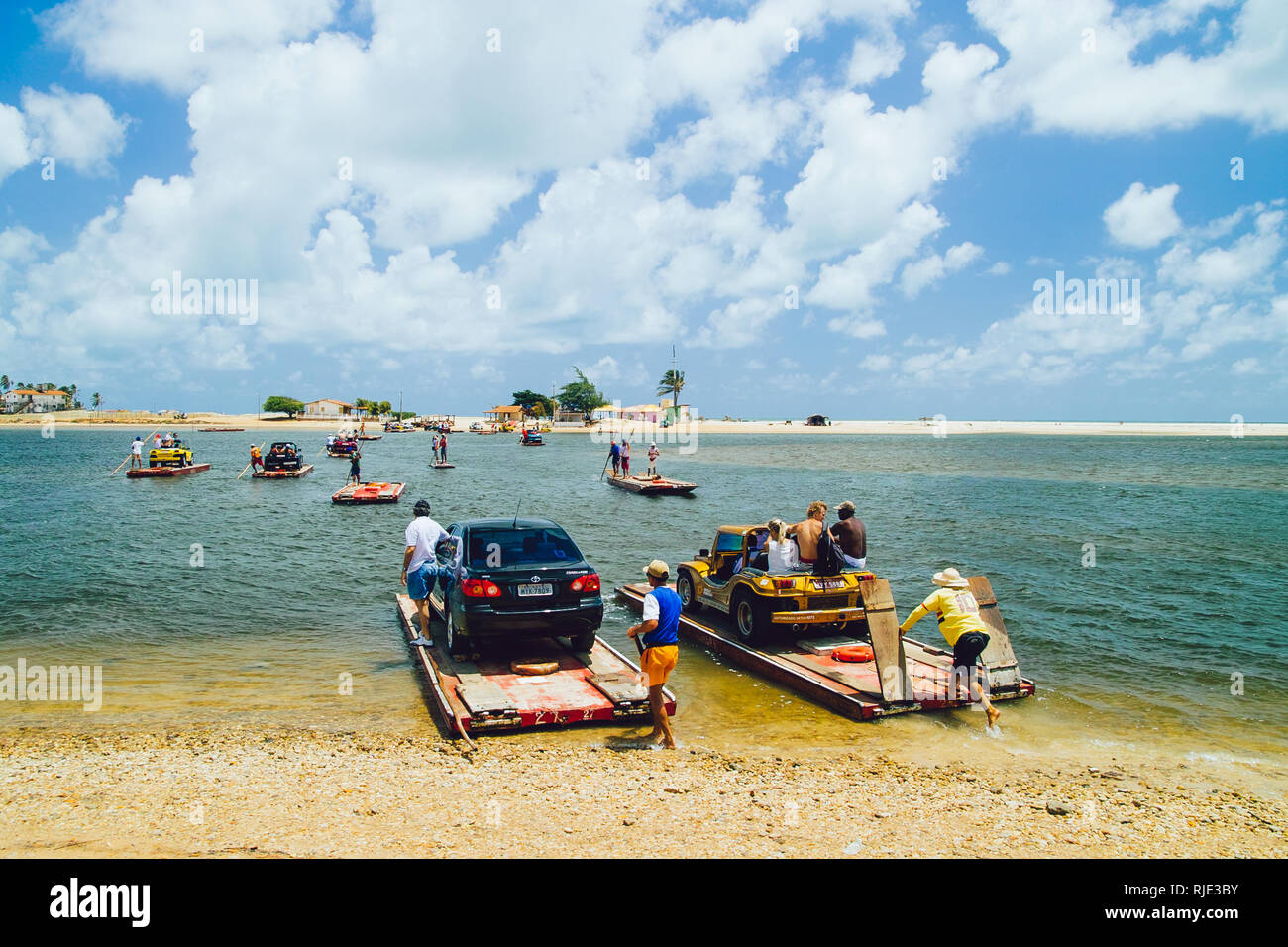 A single beach-buggy is punted across a shallow lagoon on a jangada ...